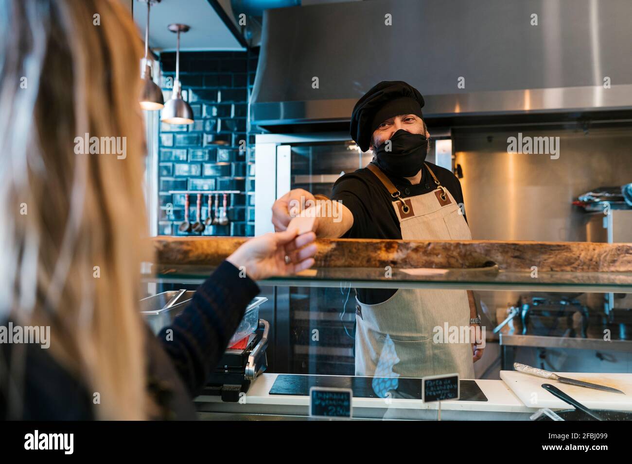 Male restaurant owner giving credit card to female customer Stock Photo ...