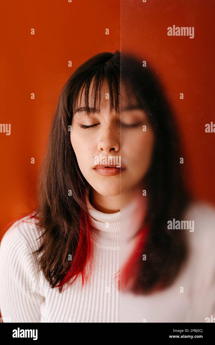 Young woman with eyes closed behind plastic sheet Stock Photo - Alamy