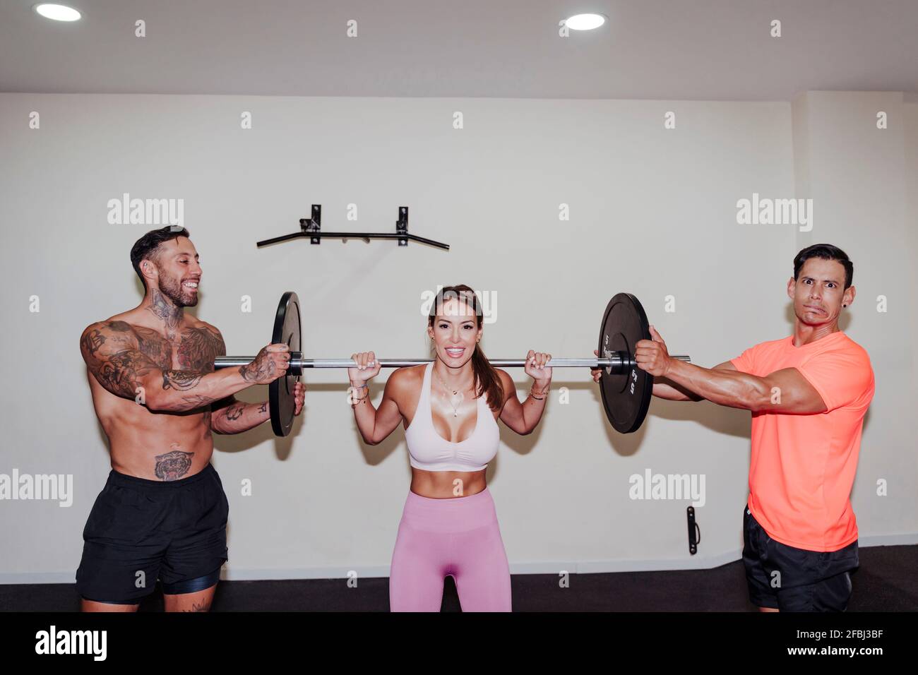 Male athletes helping friend in weightlifting Stock Photo - Alamy