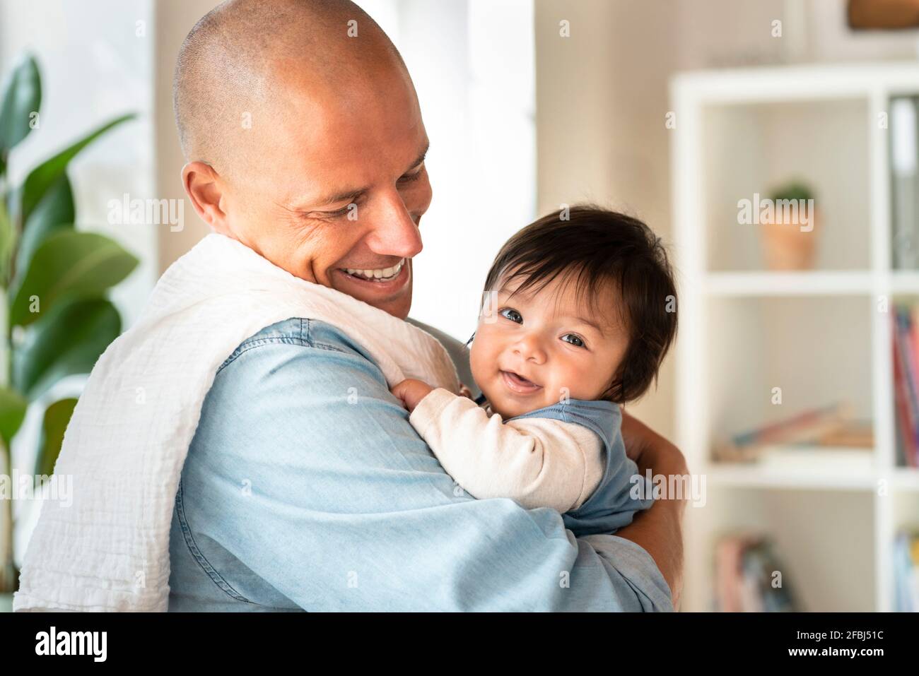 Happy father looking at smiling cute baby at home Stock Photo - Alamy