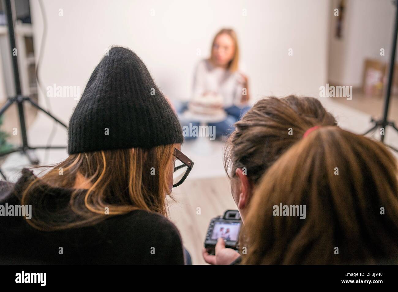 Photographer sharing camera with female coworker in studio Stock Photo ...