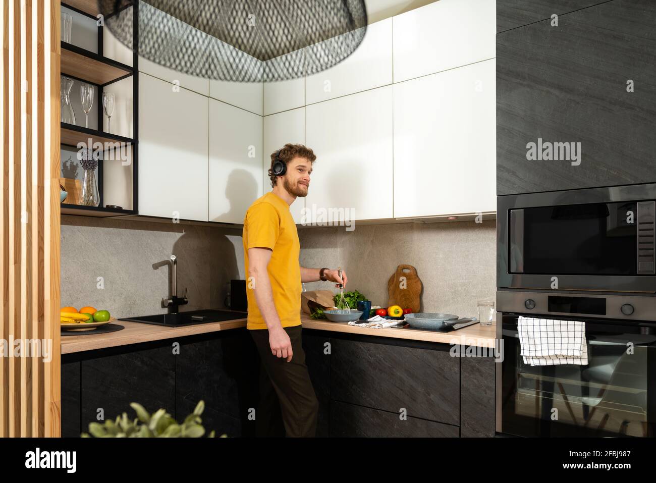 Man listening music while cooking food in kitchen at home Stock Photo ...
