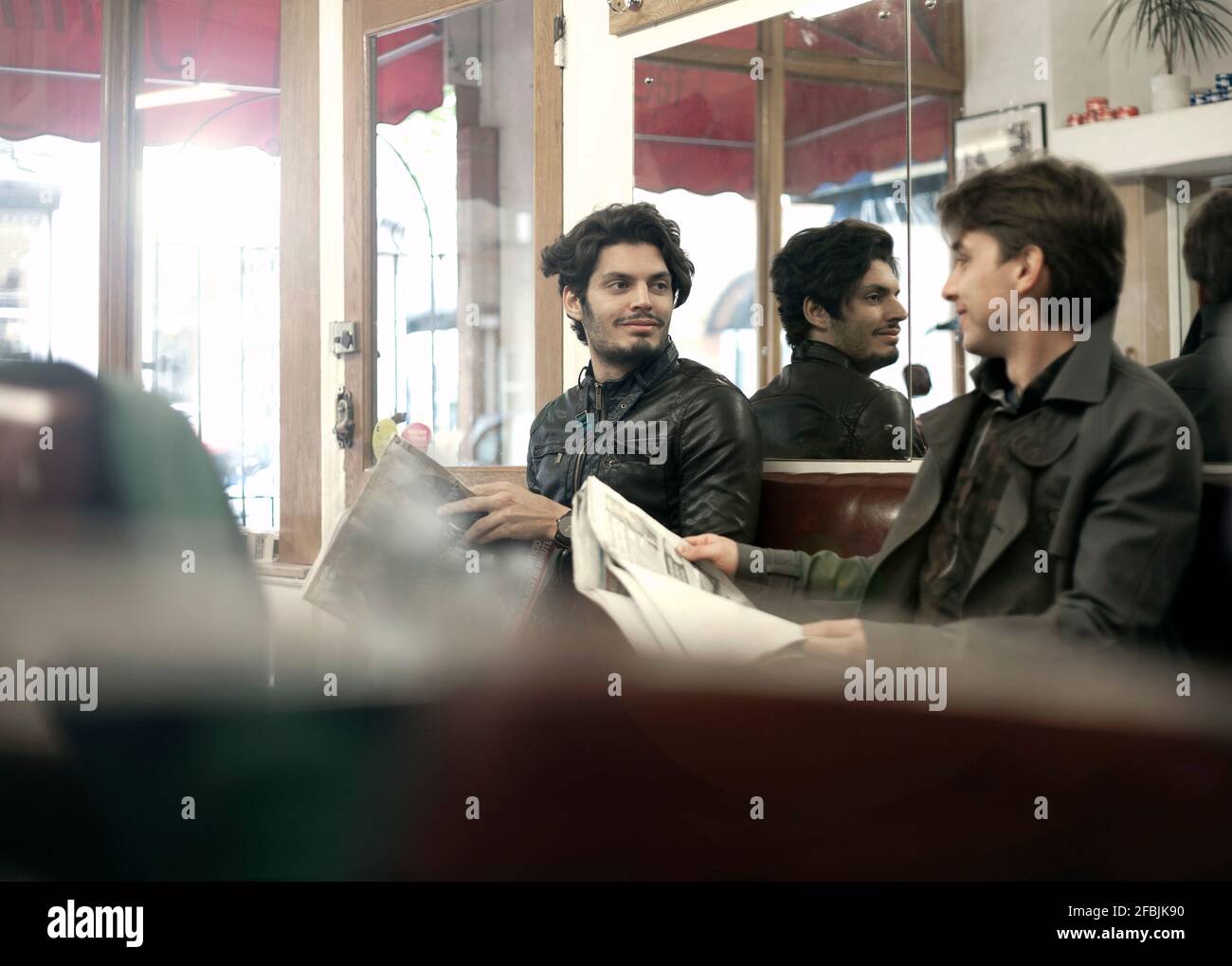 Two men talking in barber shop while waiting for haircut Stock Photo ...