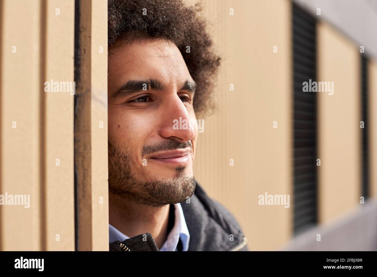 Smiling Afro man by wall Stock Photo - Alamy