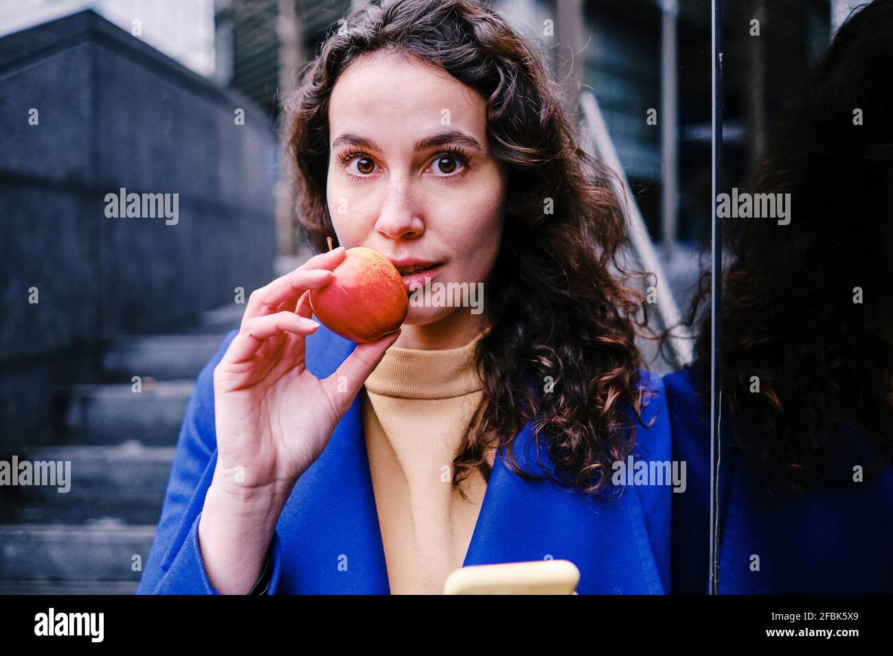 Beautiful female professional eating fresh apple Stock Photo - Alamy