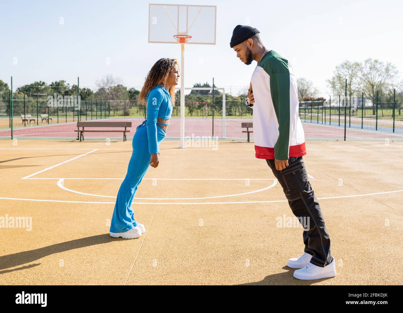 Active male and friends leaning over basketball court Stock Photo - Alamy