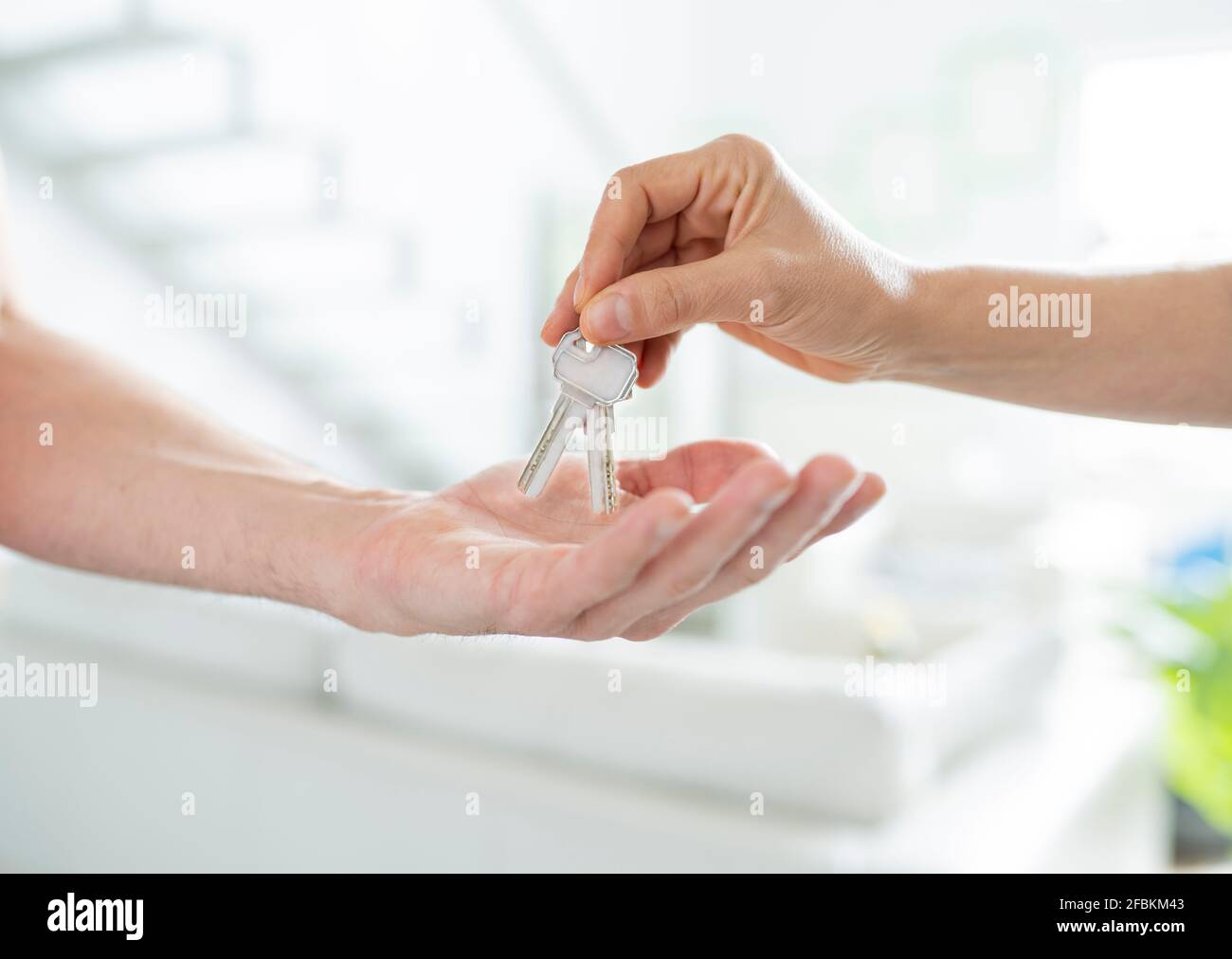Woman passing keys to man Stock Photo - Alamy