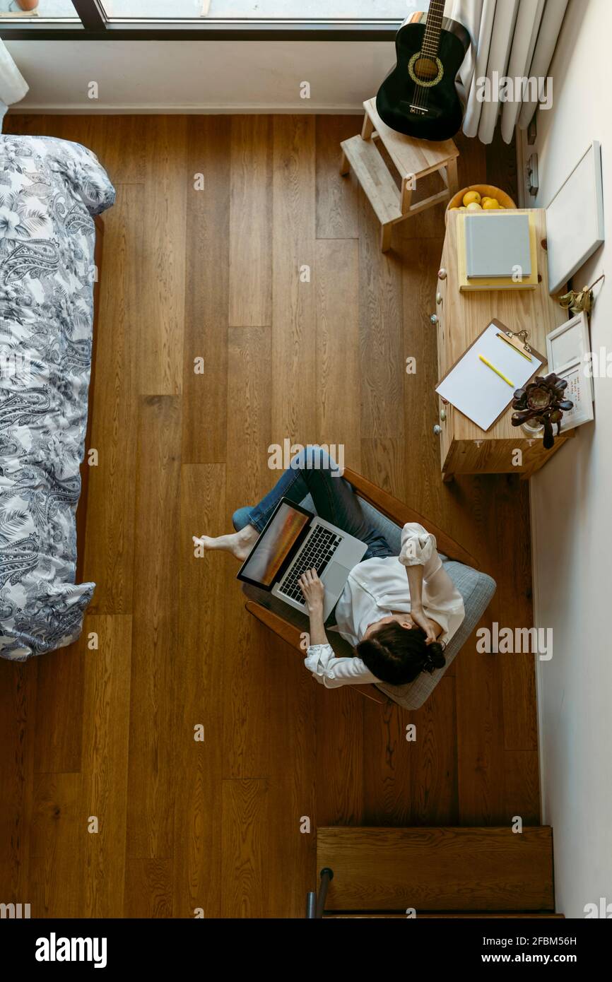 Woman using laptop in bedroom at home Stock Photo - Alamy