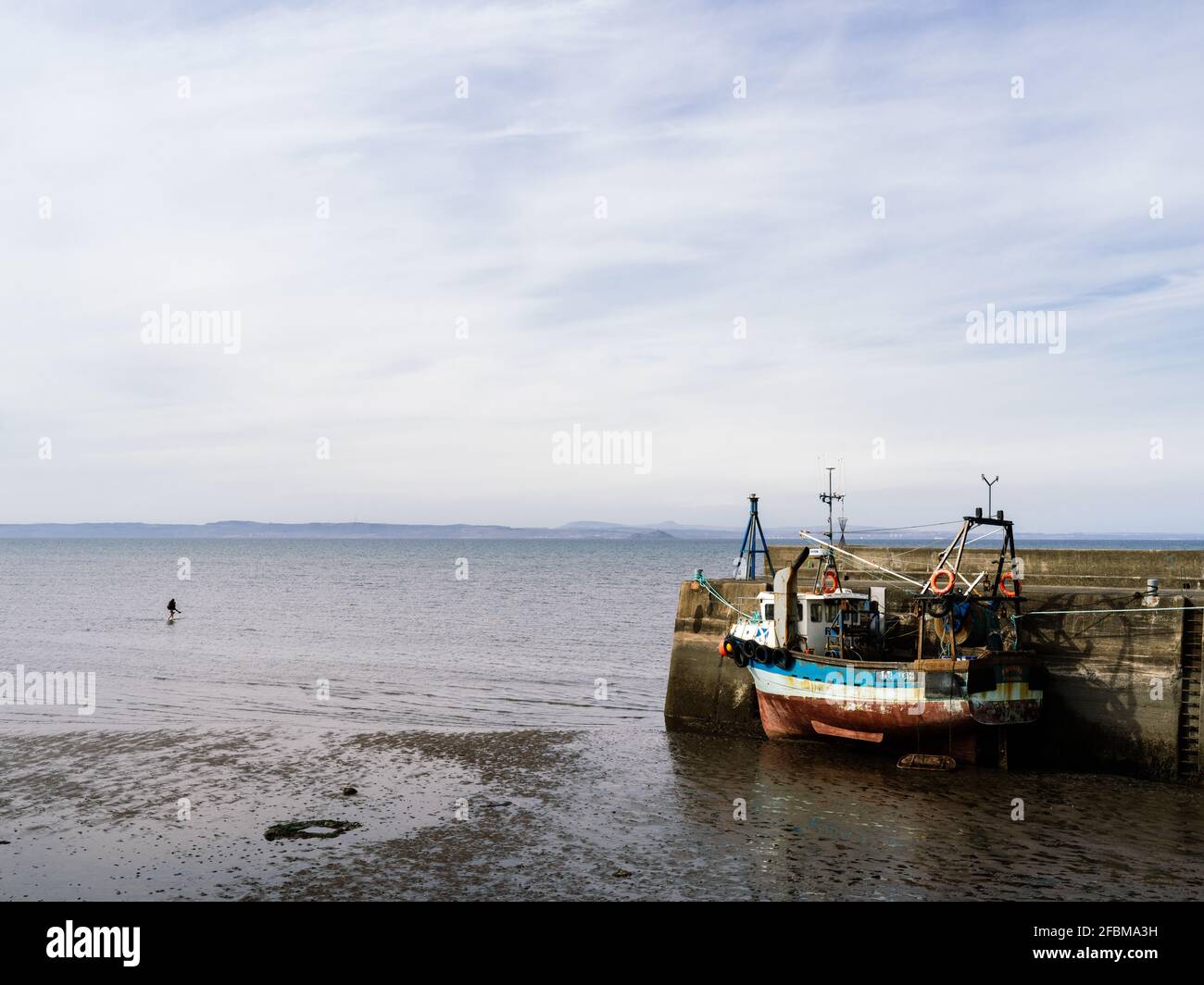 Prawn trawler tied up on the harbour entrance at low tide at Fisherrow ...