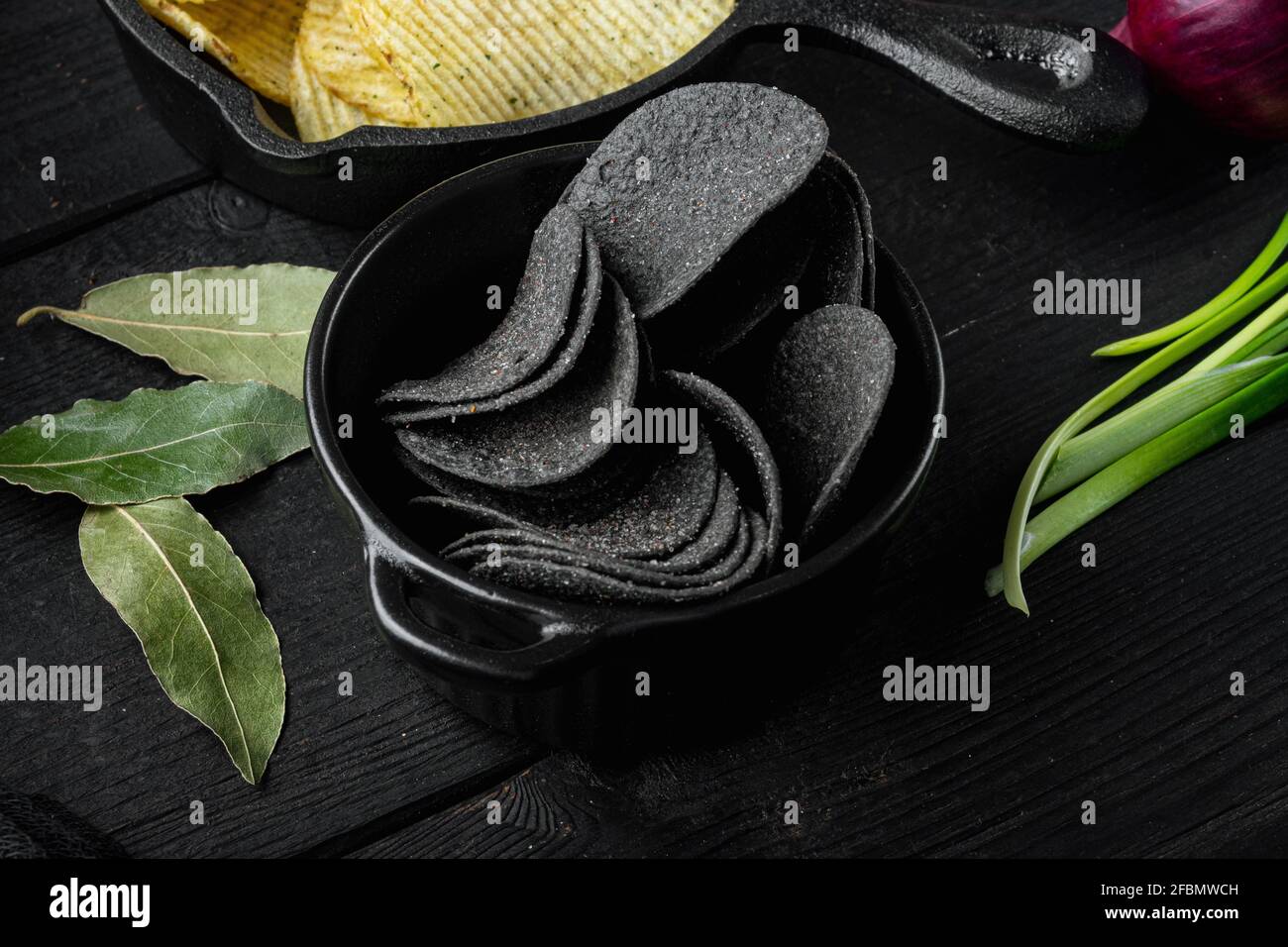 Cheese and chive potato crisp snack set, on black wooden background ...
