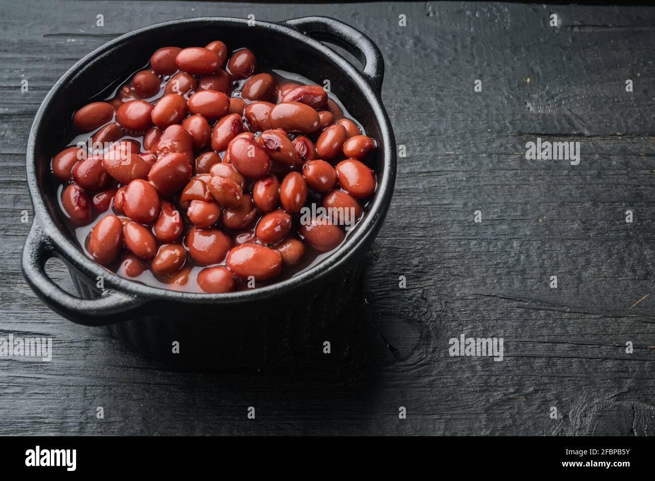 Japanese canned food ingredient, sweet red beans, on black wooden table ...