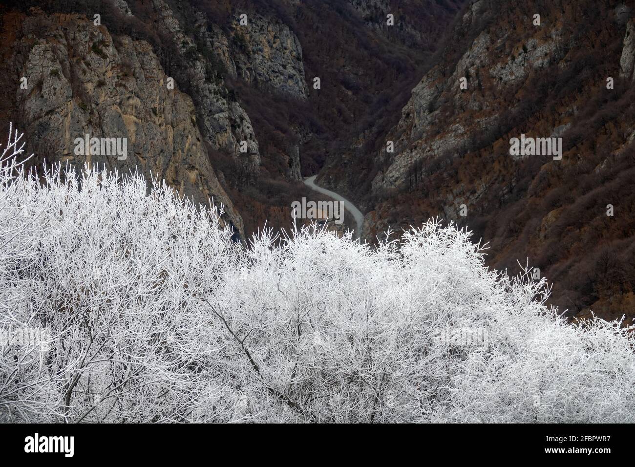 A mountain road passes through a narrow gorge (crevasse). Ice fog ...