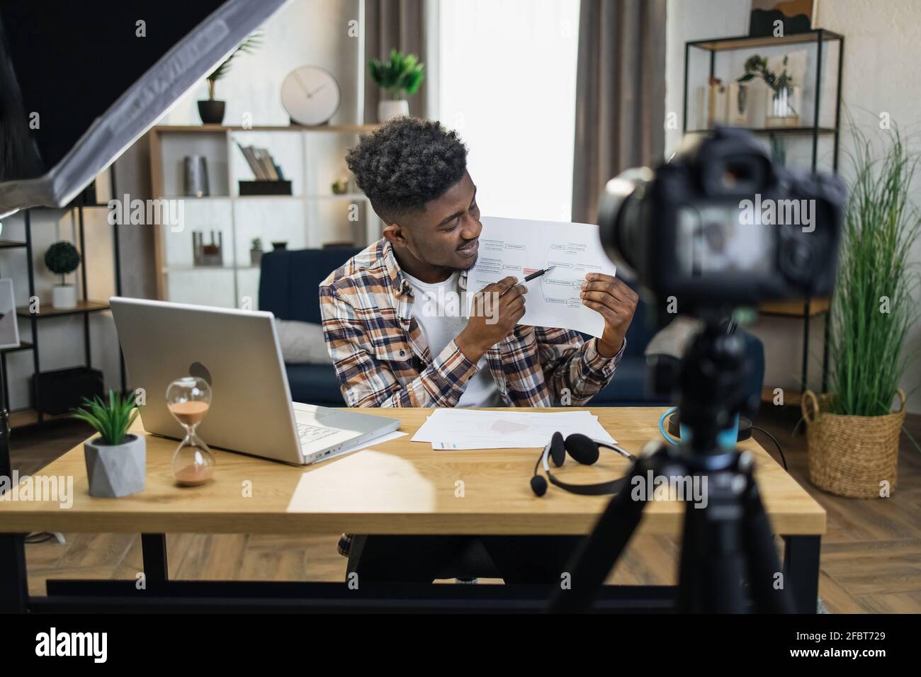 Focused african tutor recording masterclass for students using video ...