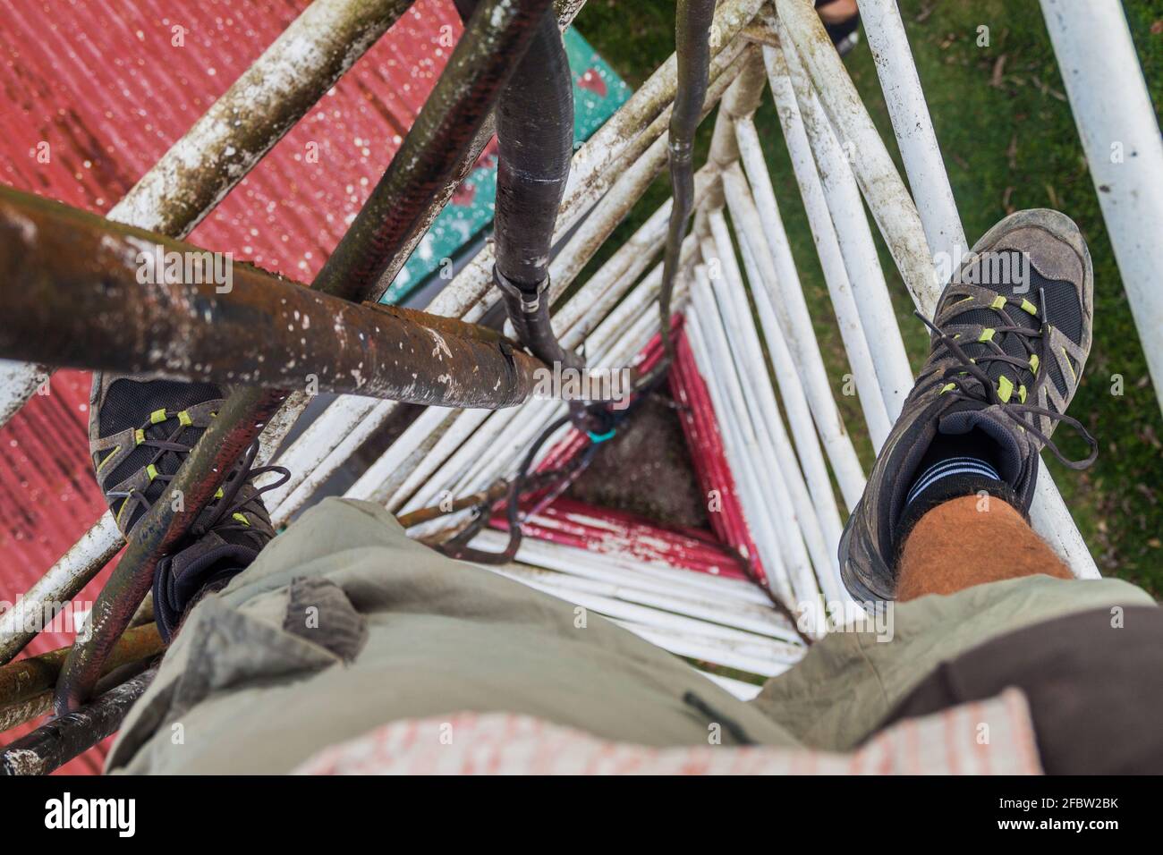 Person climbing a triangular guyed lattice mast near Santa Elena ...
