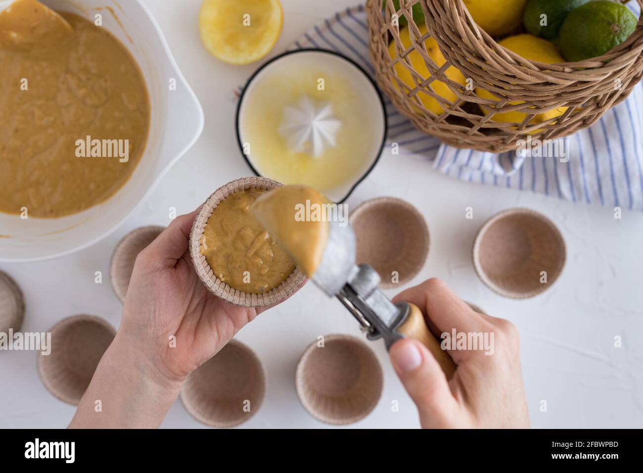 Bakery cup just filled with a muffin batter by a woman hand using a ...