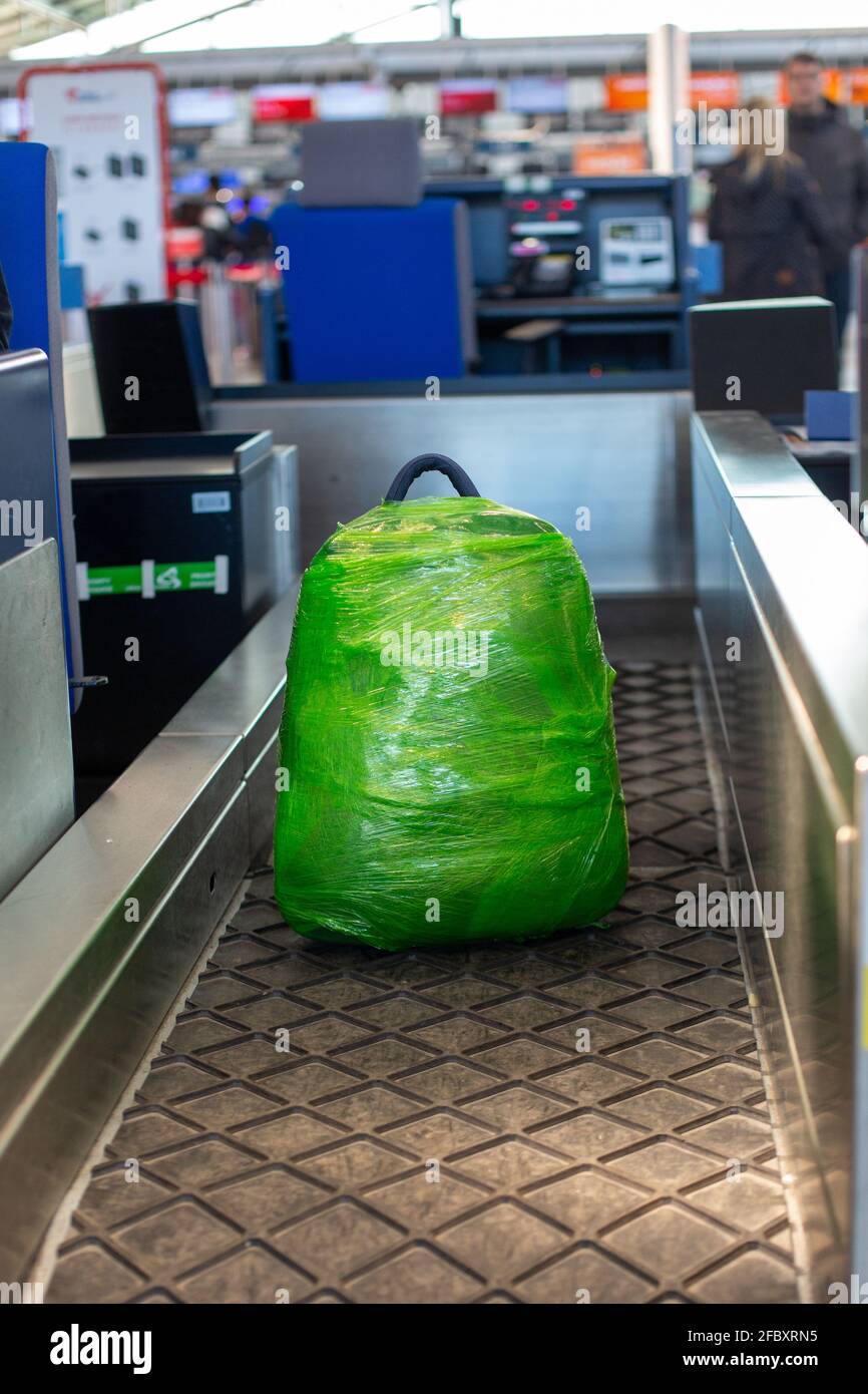 backpack wrapped in green plastic weighed at check-in counter before ...