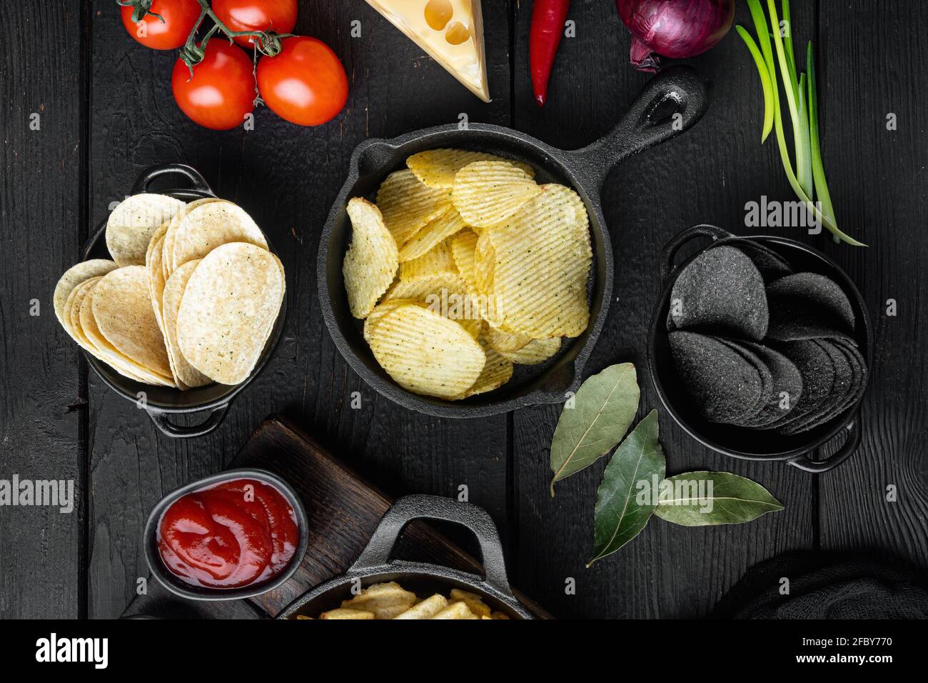 Variation different potato chips set, on black wooden background, top ...