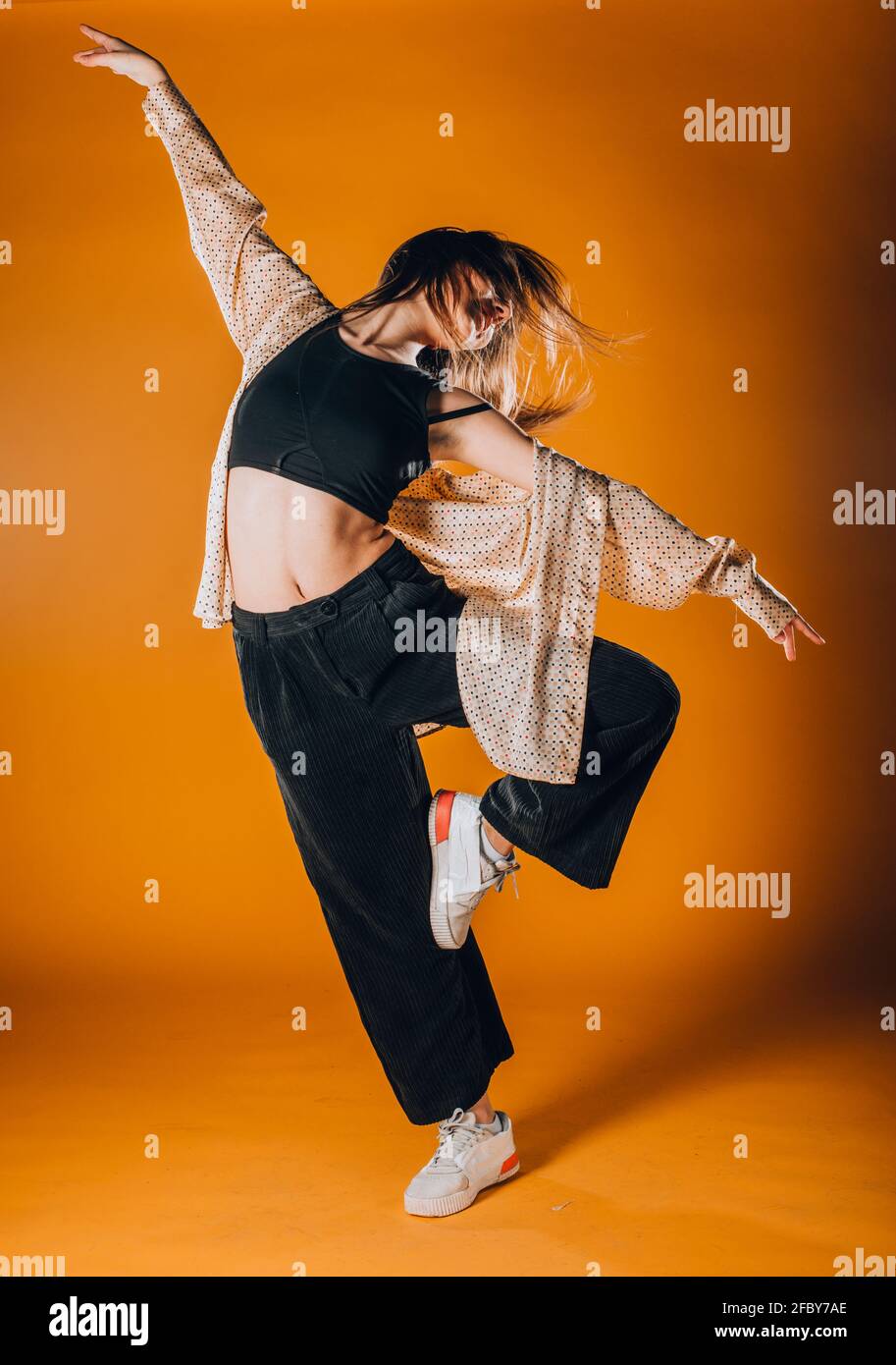 Flexible young dancer performing a stylish dance movement Stock Photo ...