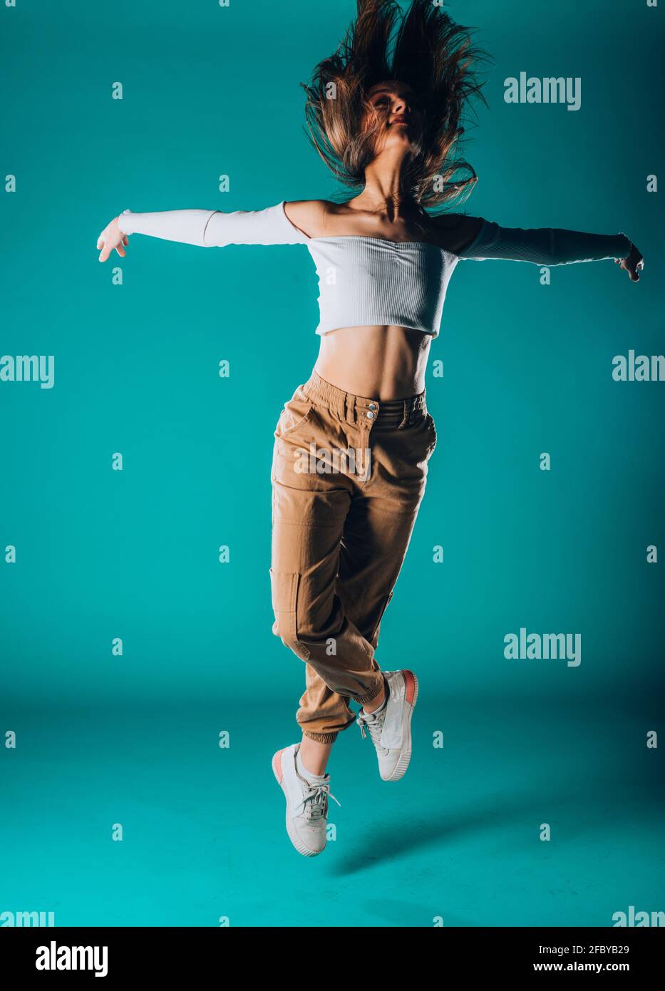 Young athletic girl performing contemporary dance moves while jumping ...
