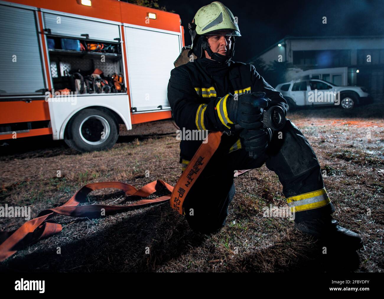Firemen using fire hose that shoots foam and water during an emergency ...