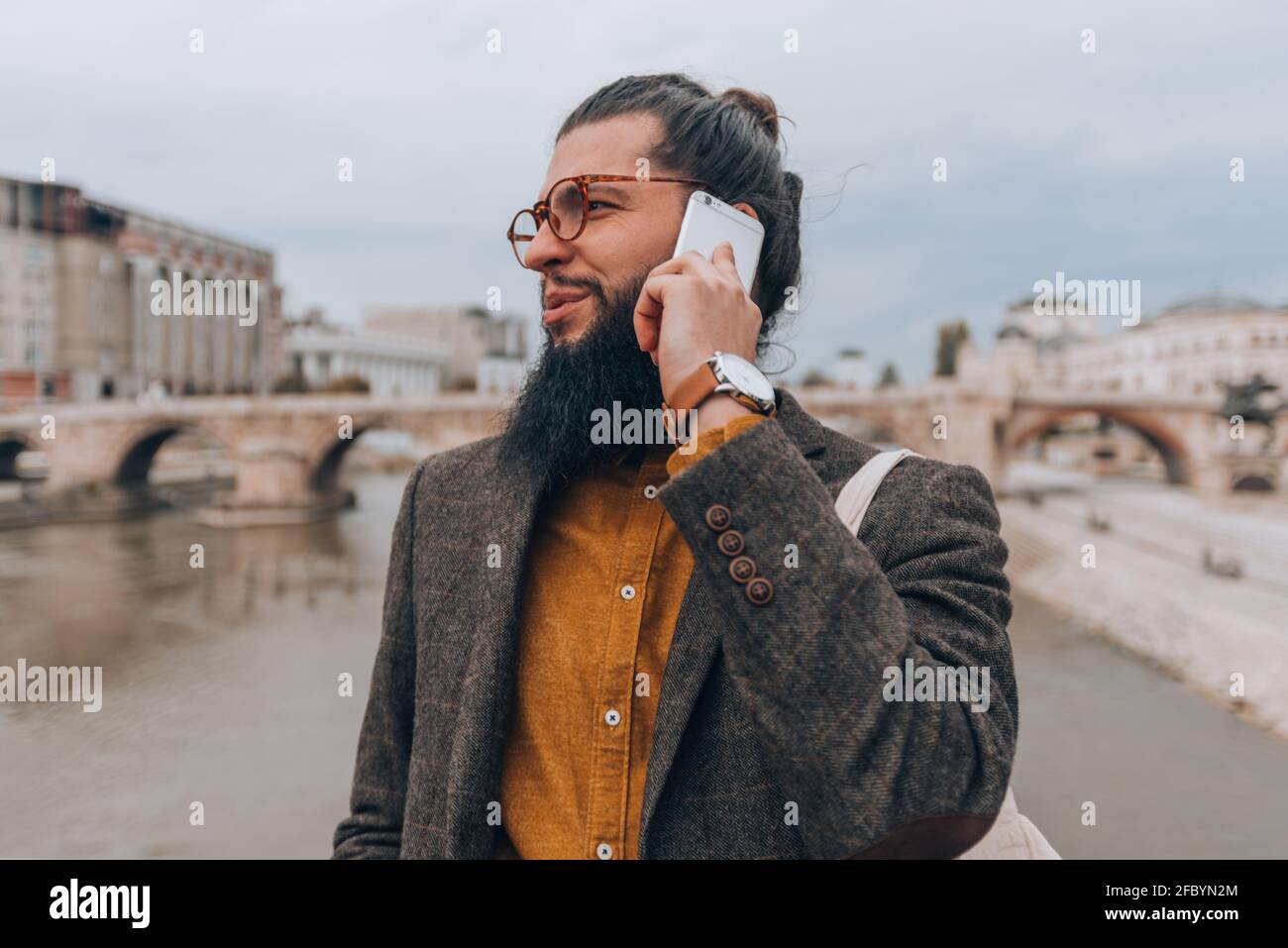 Stylish caucasian male clothed in a fashionable outfit making a phone ...