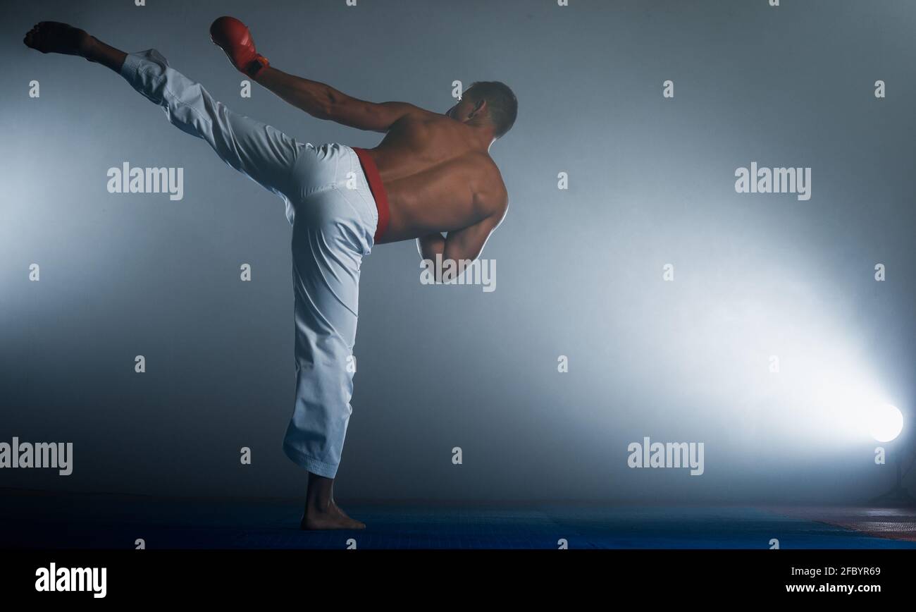 A young strong man in a white kimono for sambo, jiu jitsu and other ...