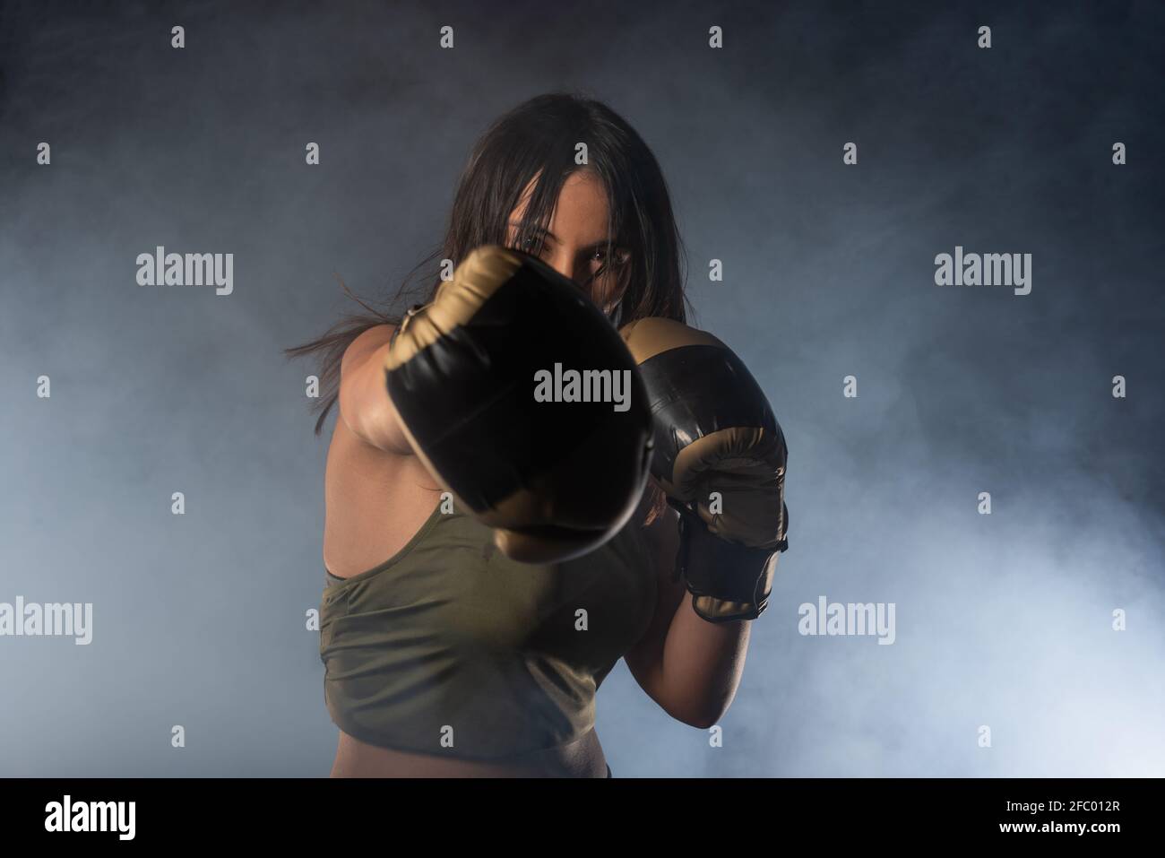 Closeup portrait of a female boxer posing with boxing gloves and ...