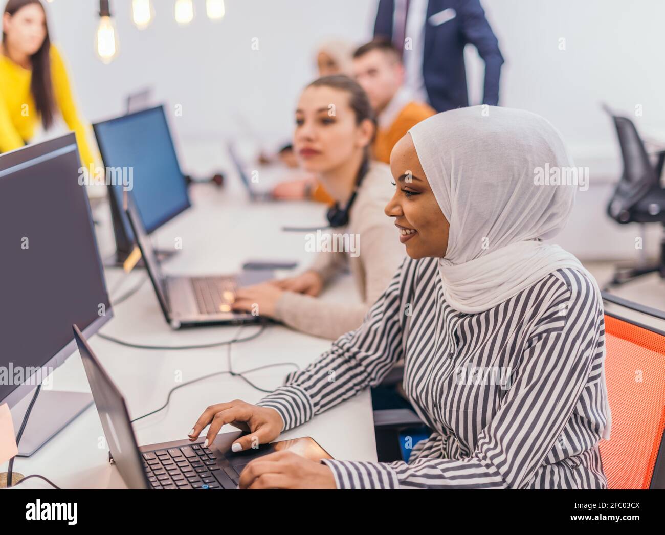 Surprised african muslim woman working in bright coworking space on ...