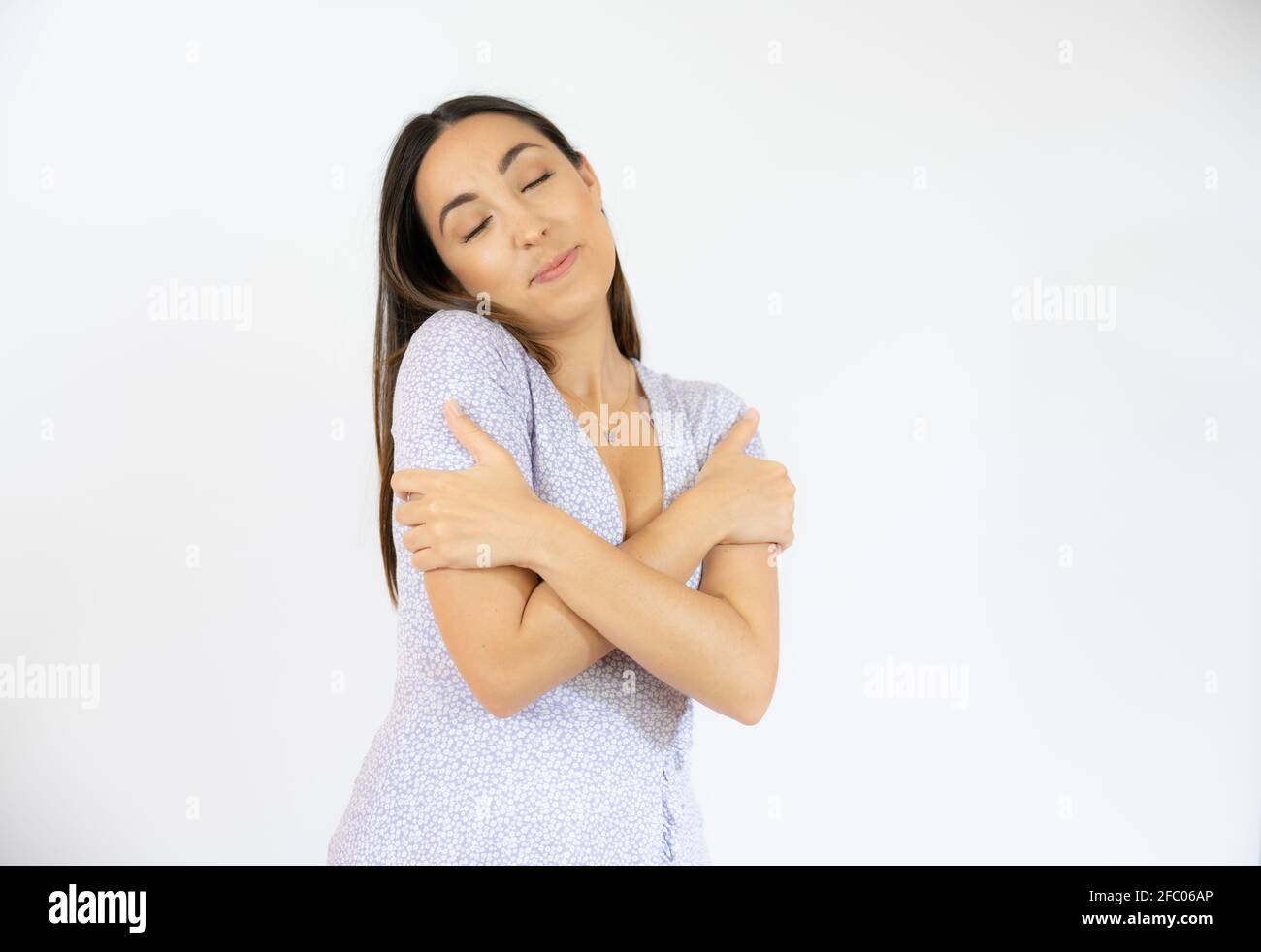 Young woman hugging herself isolated over white background Stock Photo ...