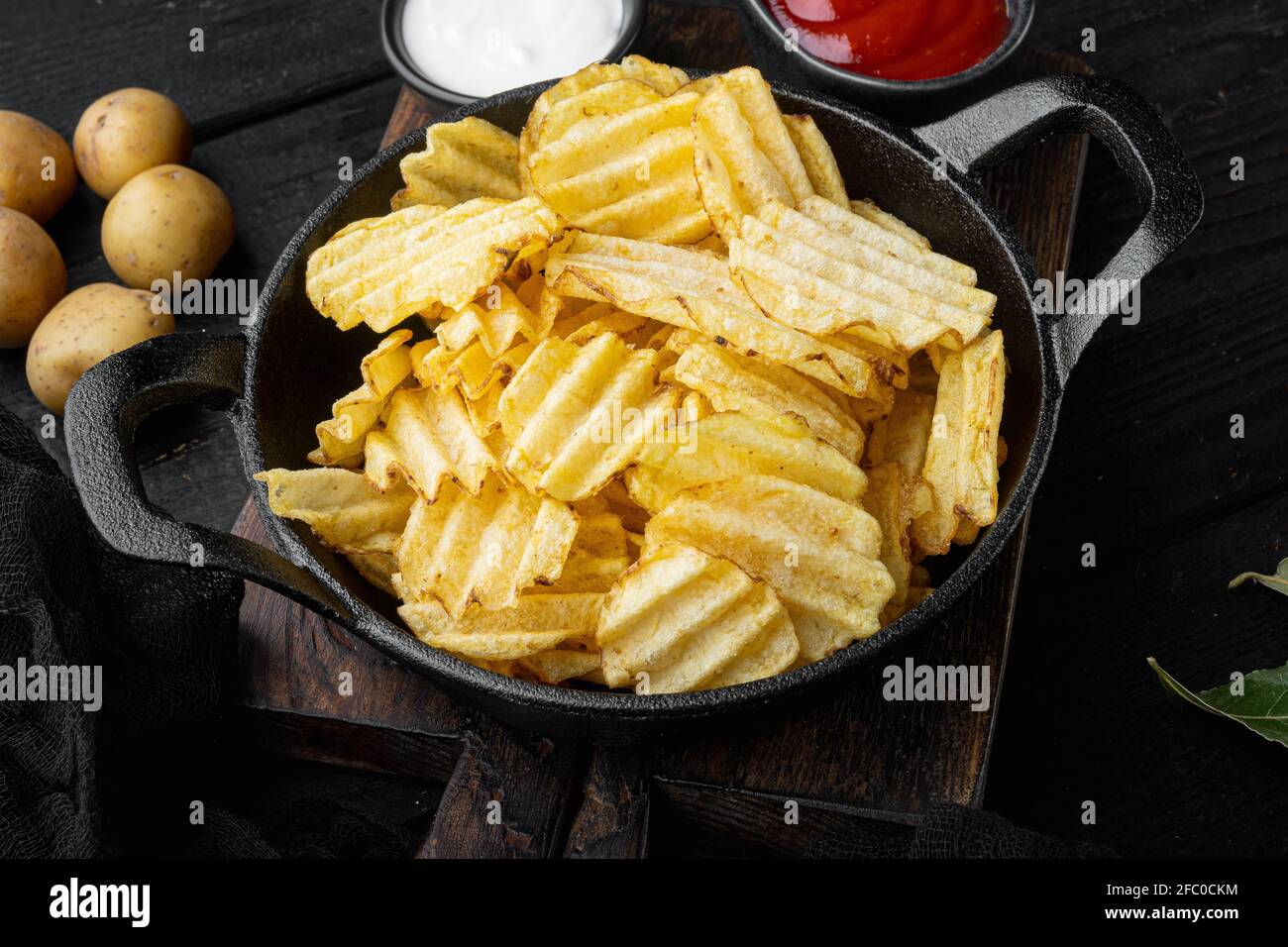 Potatoe chips set, on black wooden background Stock Photo - Alamy