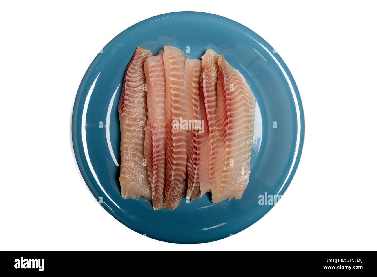 Close up of fresh or unfrozen set of filleted fish in a blue plate ...