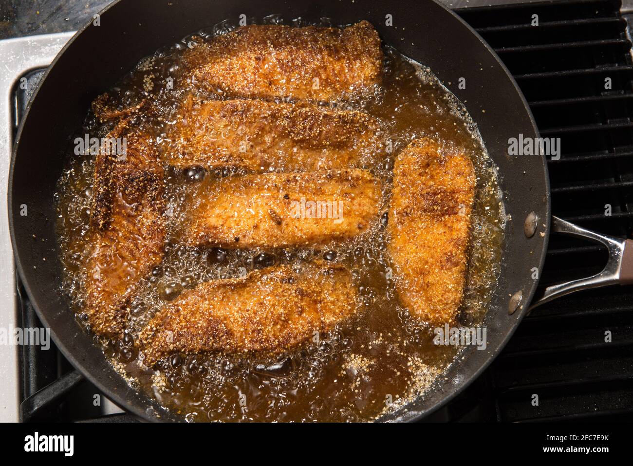 Pan-frying or home cooking fish fillet on a stove top Stock Photo - Alamy