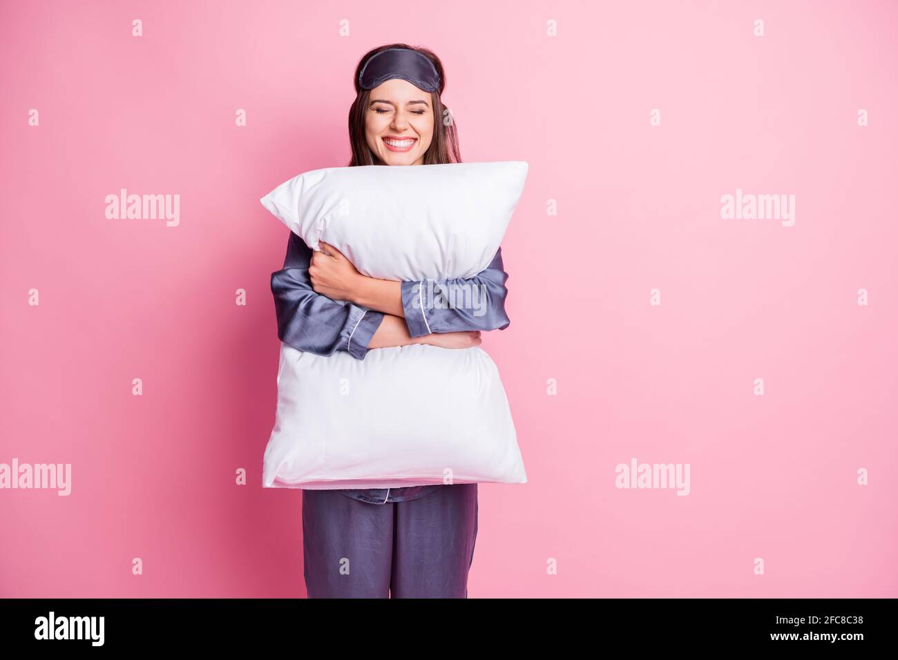 Photo portrait of cheerful woman hugging pillow with two hands isolated ...