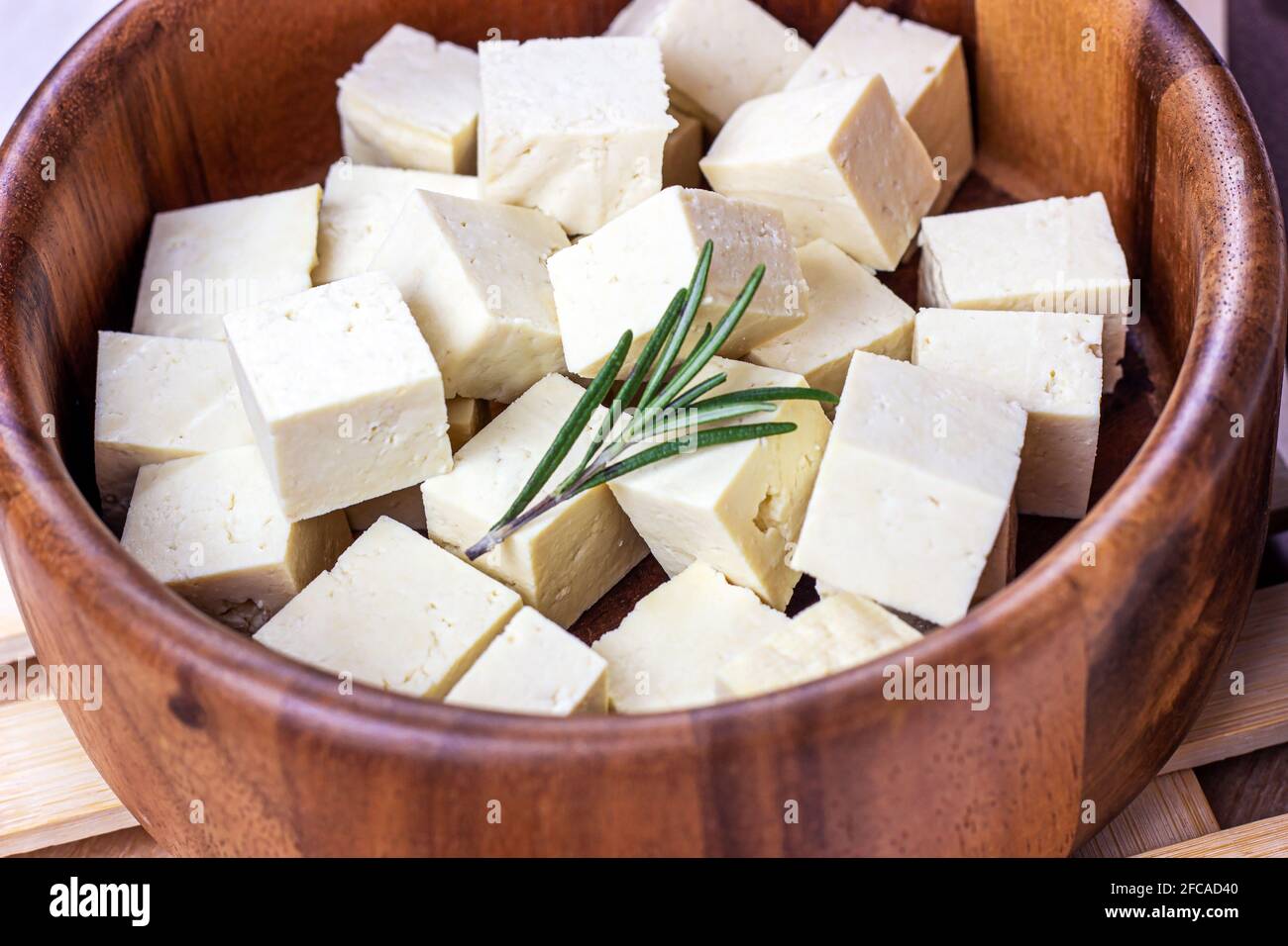 Raw organic vegetarian tofu cubes in round wooden bowl with fresh ...