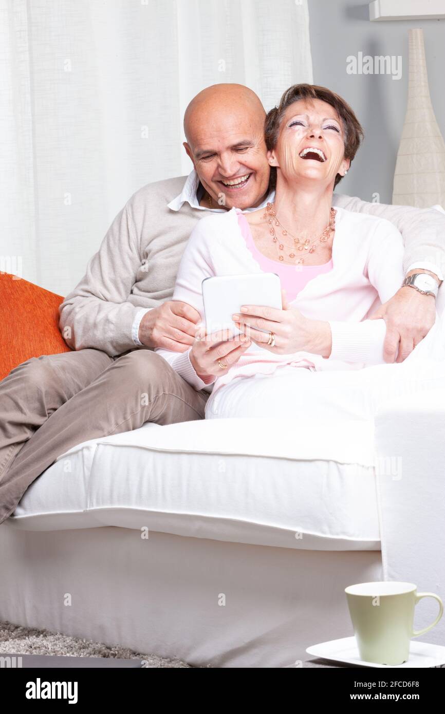Fun loving married middle-aged couple enjoying a good joke laughing ...