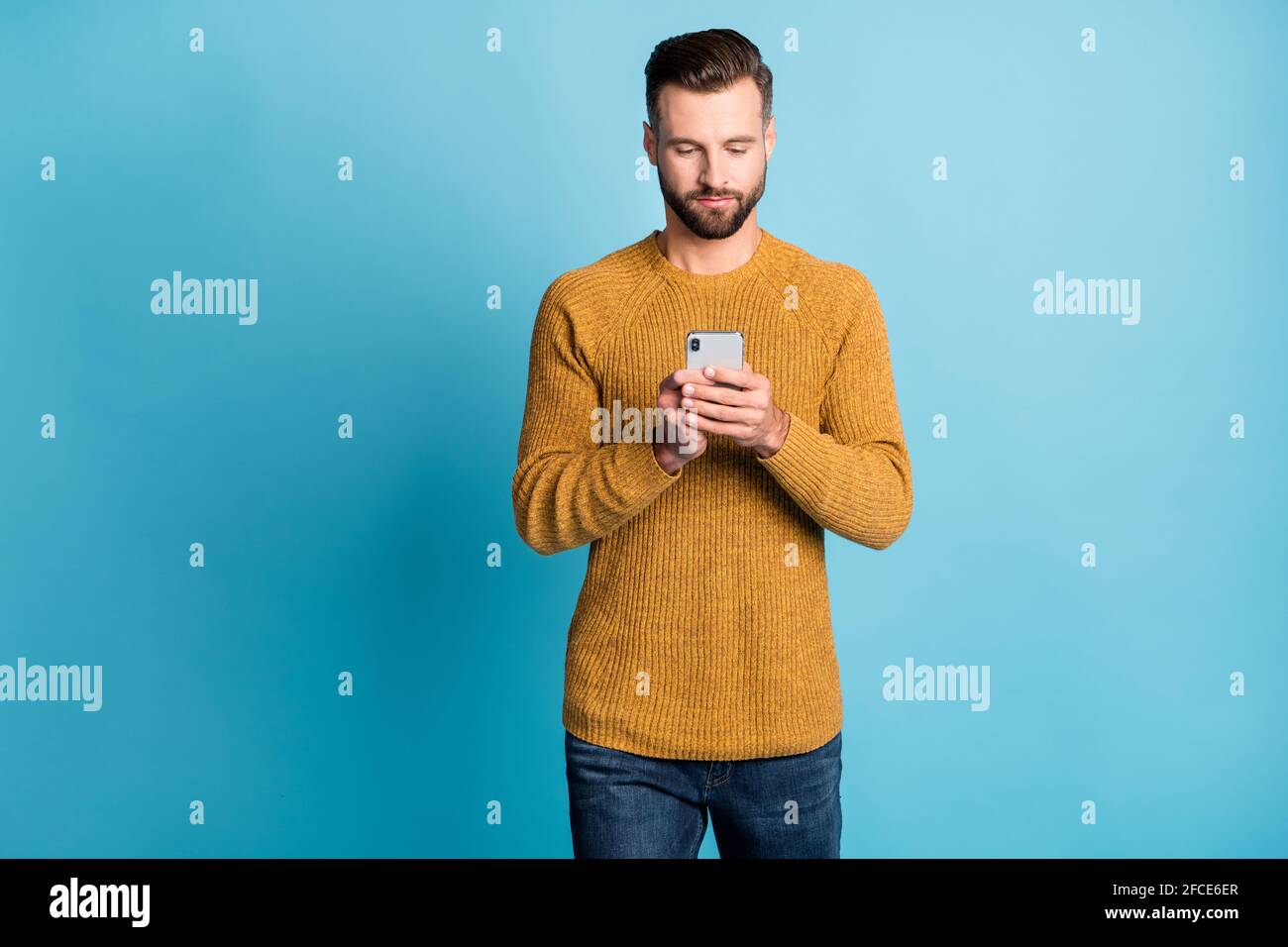 Portrait of attractive focused addicted guy wearing knitted sweater ...