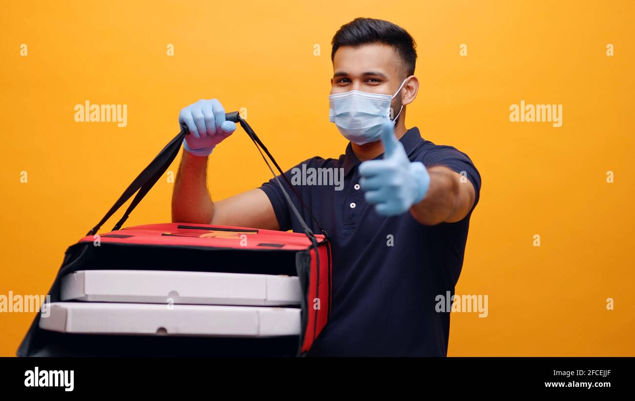 Delivery man smiling while holding pizza boxes. Ordering food during ...