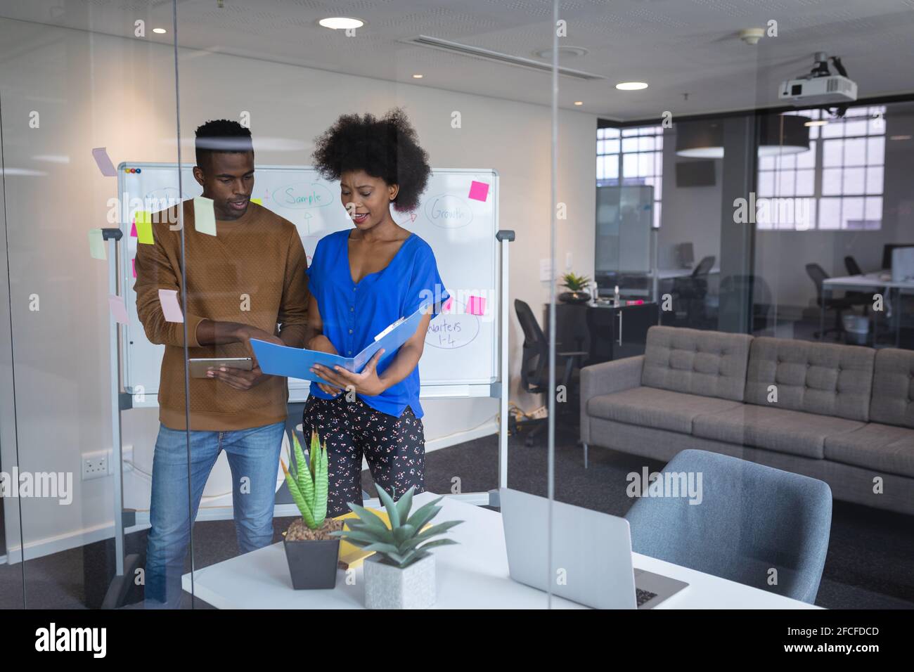 Diverse male and female colleagues standing having discussion with ...