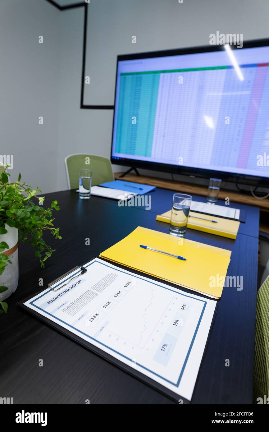 Office table with computer monitor, documents and glasses of water ...
