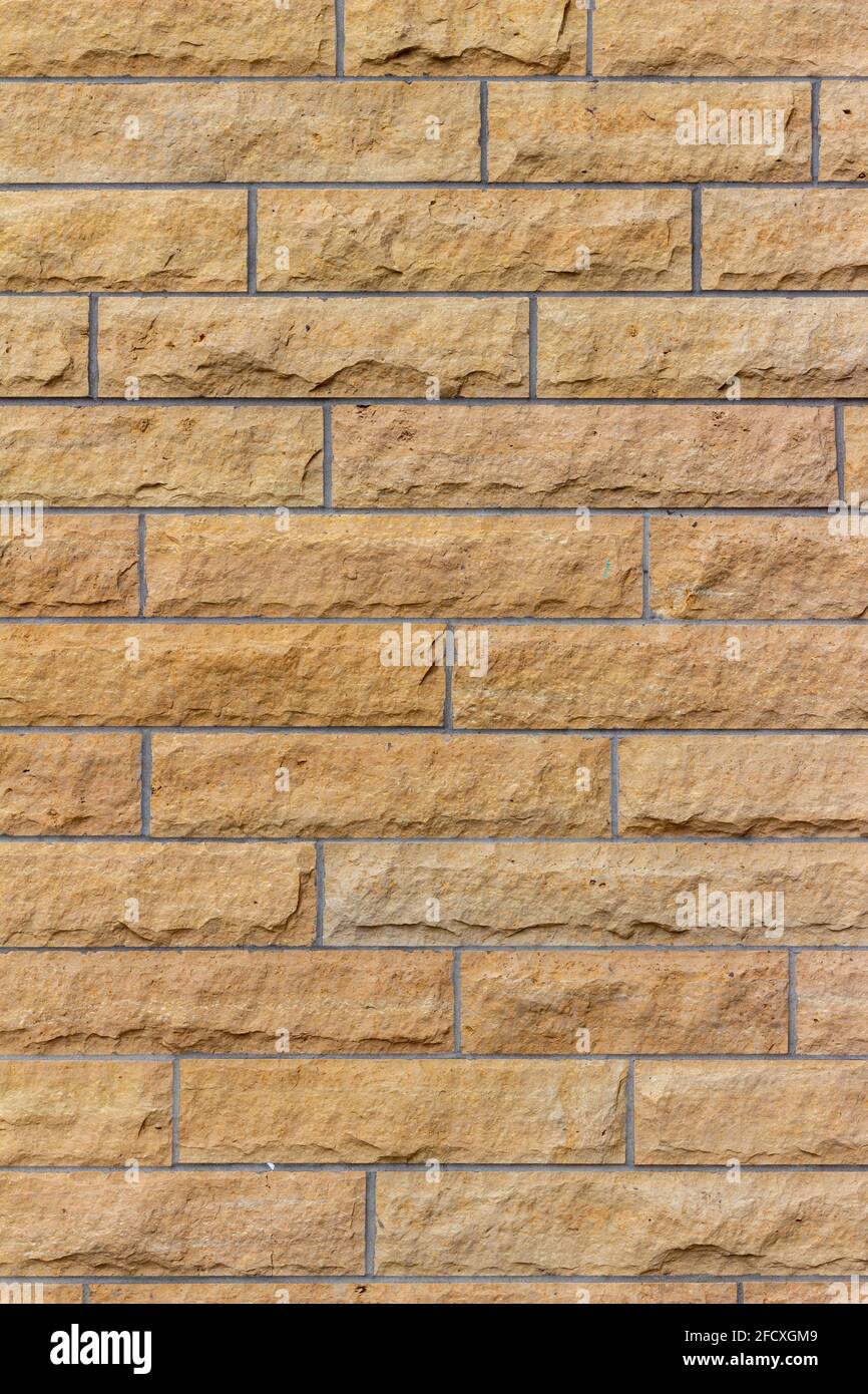 Natural rough textured stone block wall background in shades of beige ...