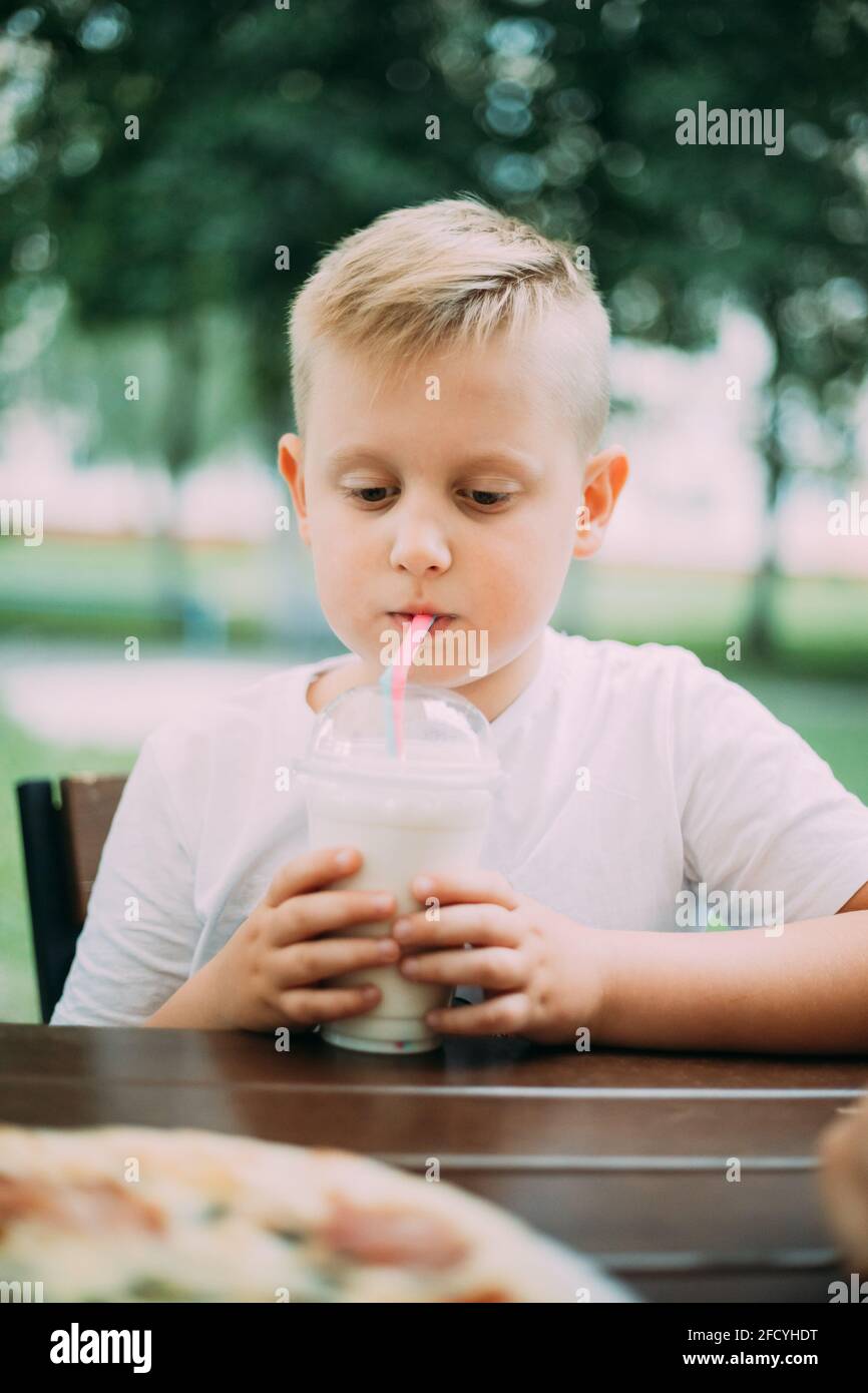 Little Boy Drinking Milkshake In Cafe In Summer Day Stock Photo - Alamy