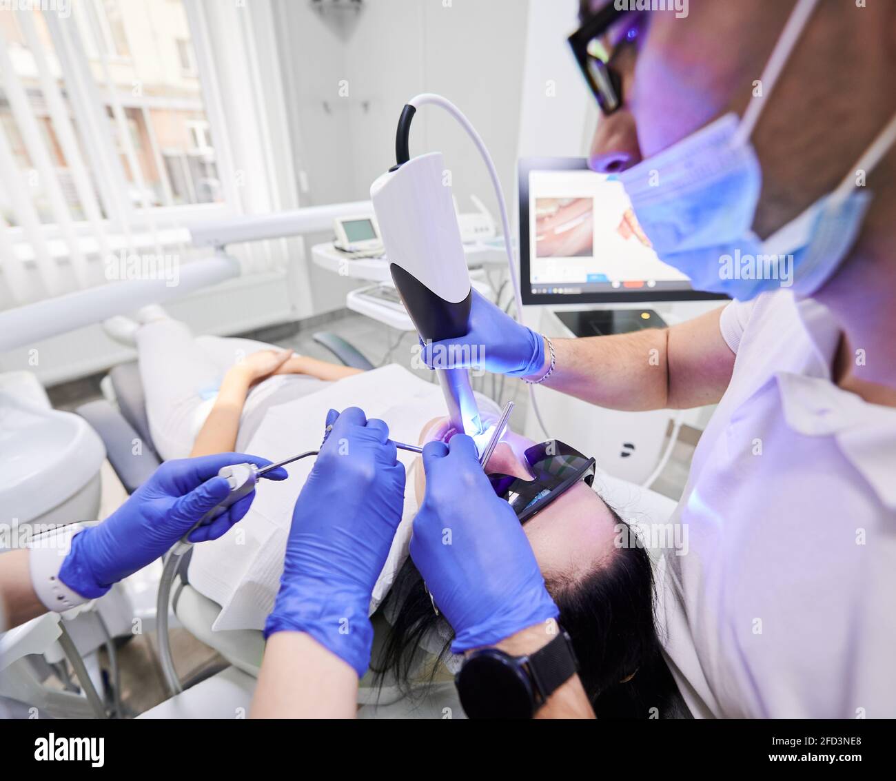 Dentist and his assistant scanning patient's teeth with modern scanning ...