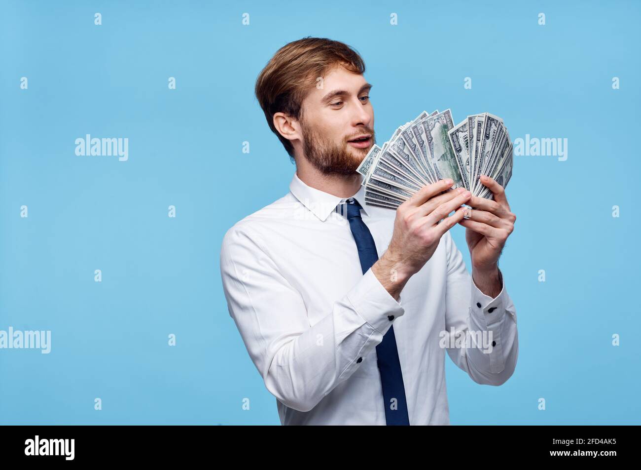 rich man in suit with money in hands emotions blue background Stock ...