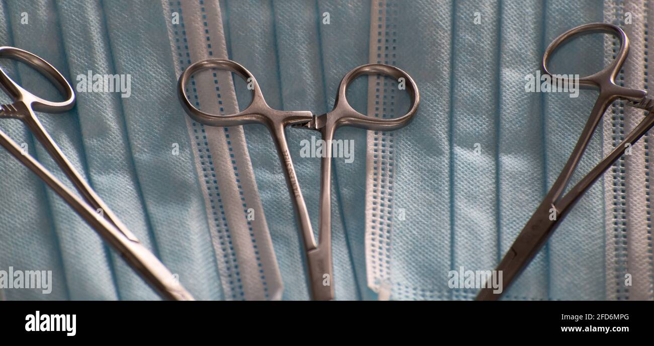 Hemostatic Forceps scissors on top of surgical face masks close-up ...
