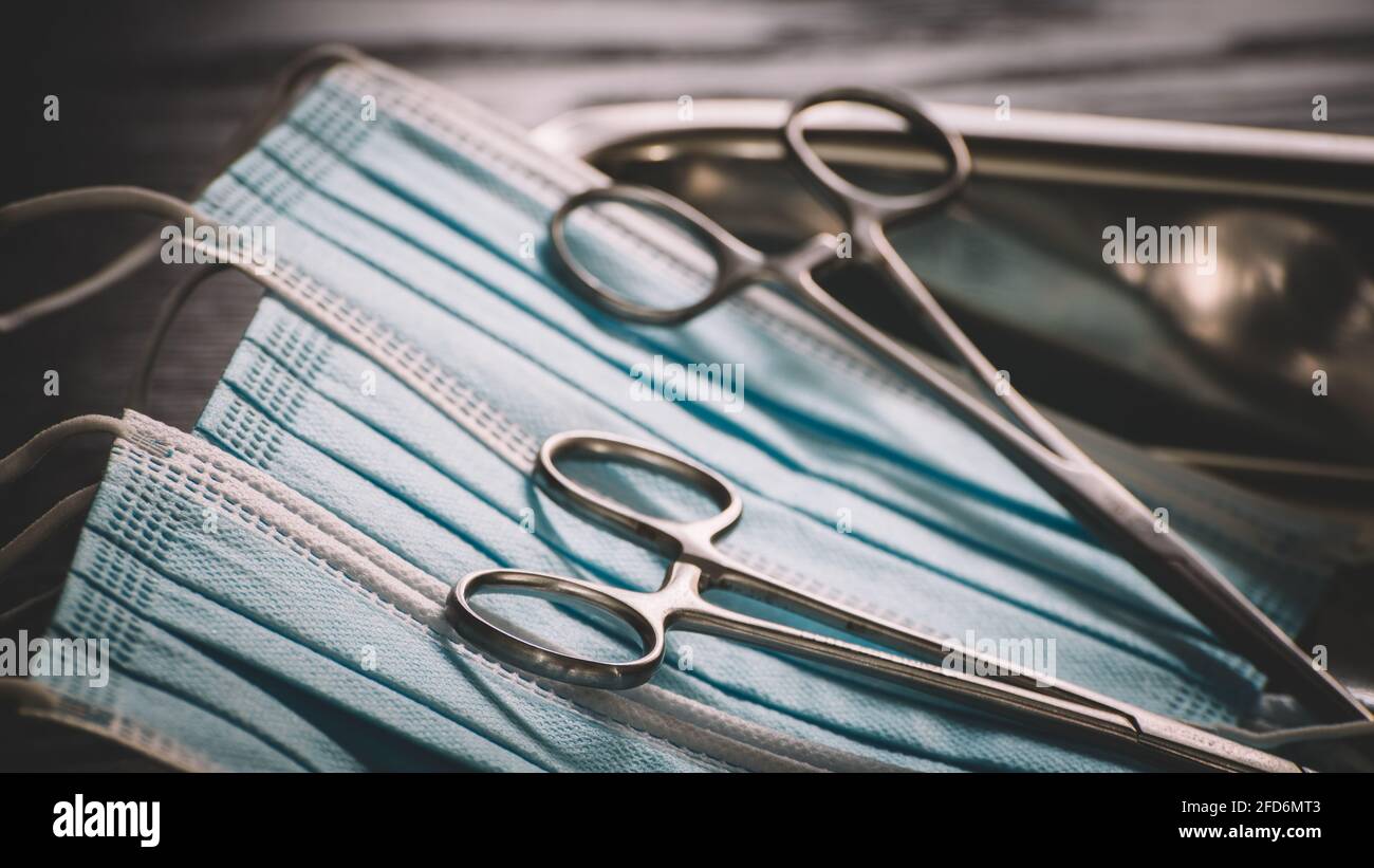 Hemostatic Forceps scissors on top of surgical face masks in a ...