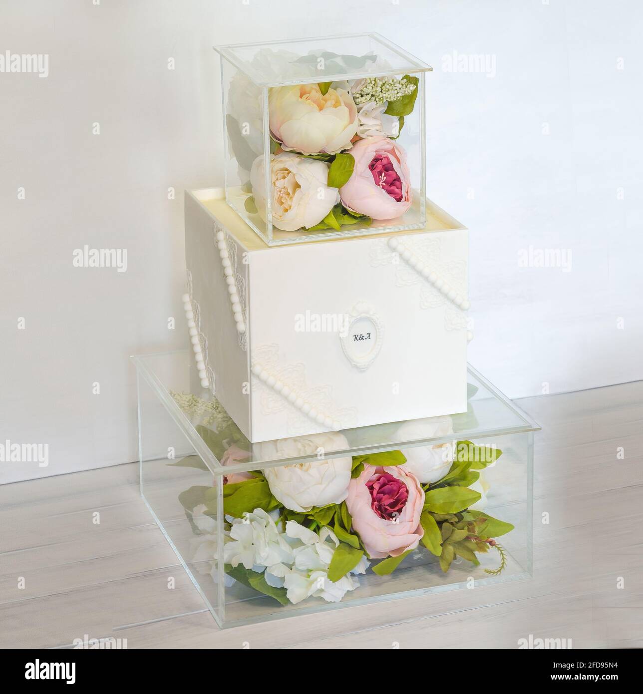 Triumph wedding cake with square cube glass construction Stock Photo ...