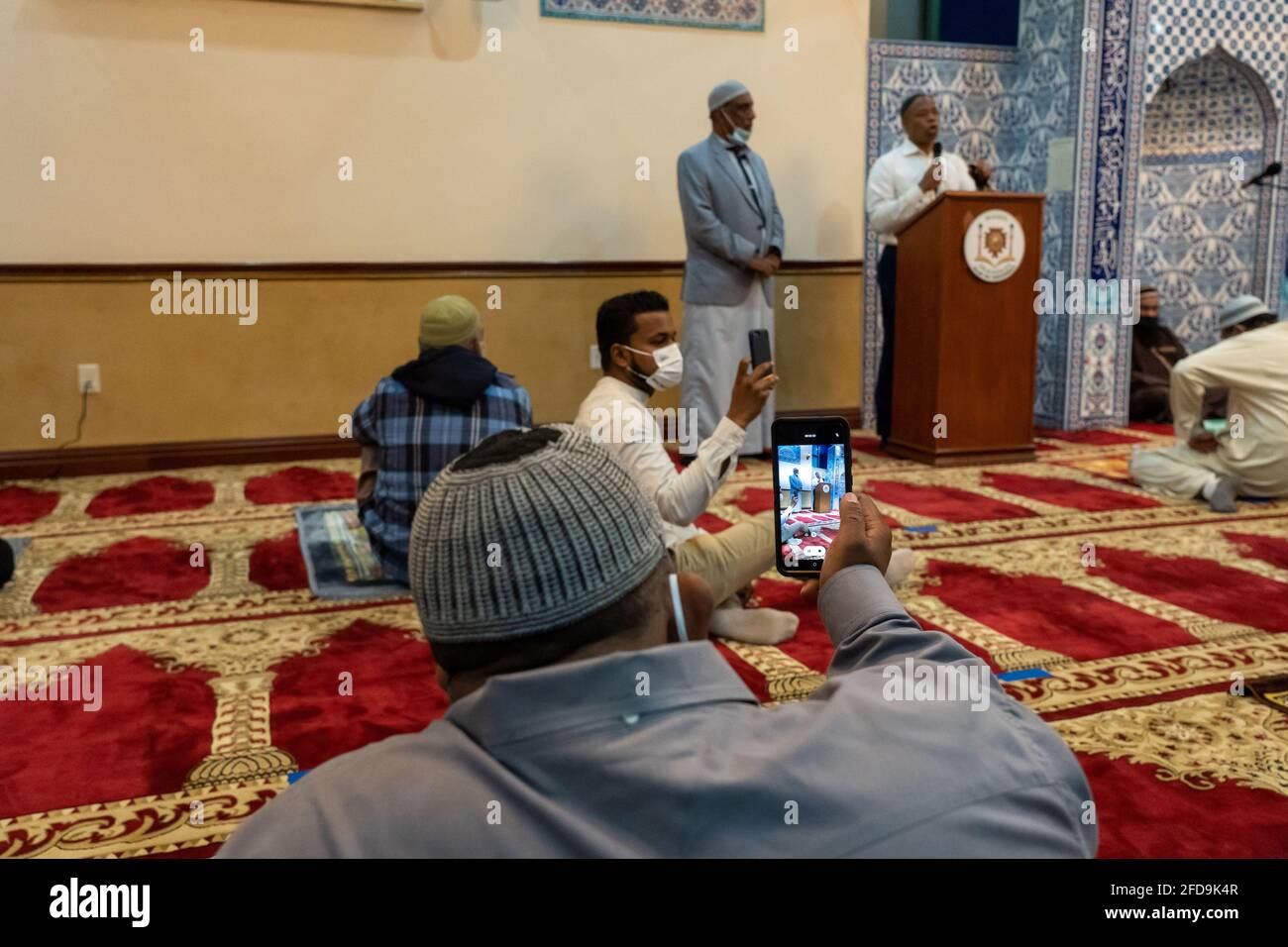 A Muslim records Mr. Adams on his phone at the Masjid Ar-Rahman mosque ...