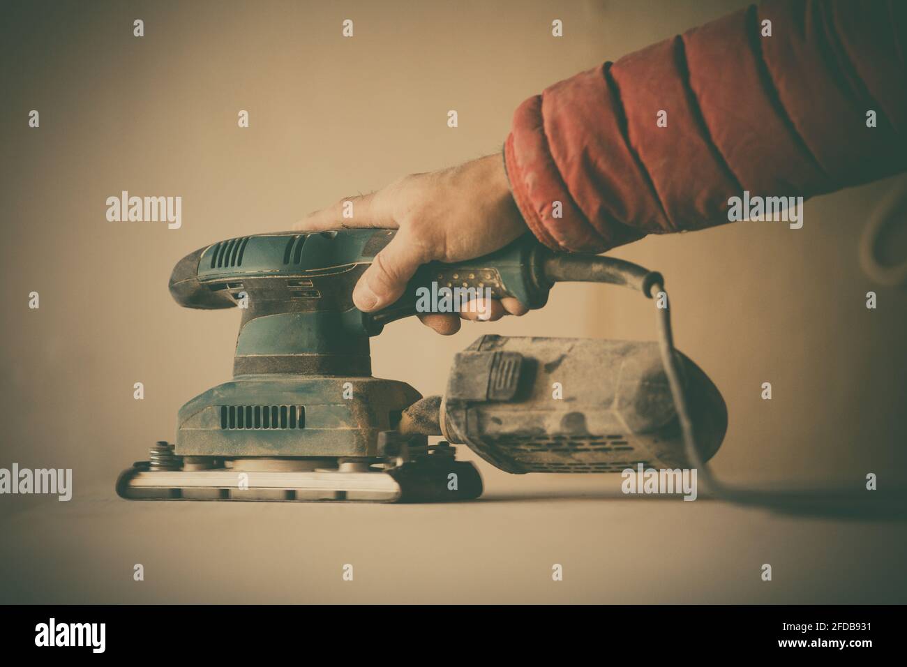 Man sanding wood plank using electric sand machine Stock Photo - Alamy
