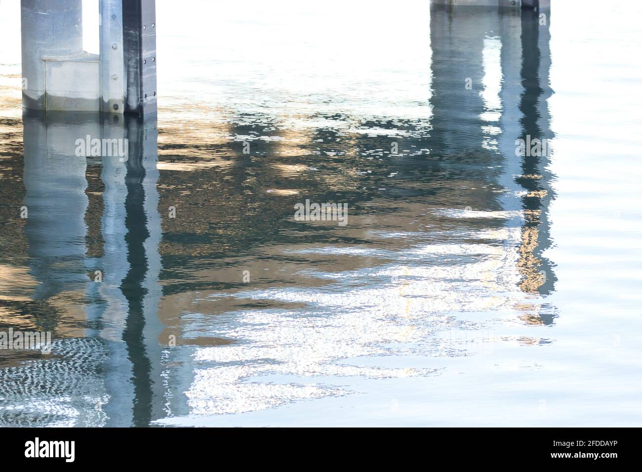 steel supports under a boardwalk coming up out of the water Stock Photo ...