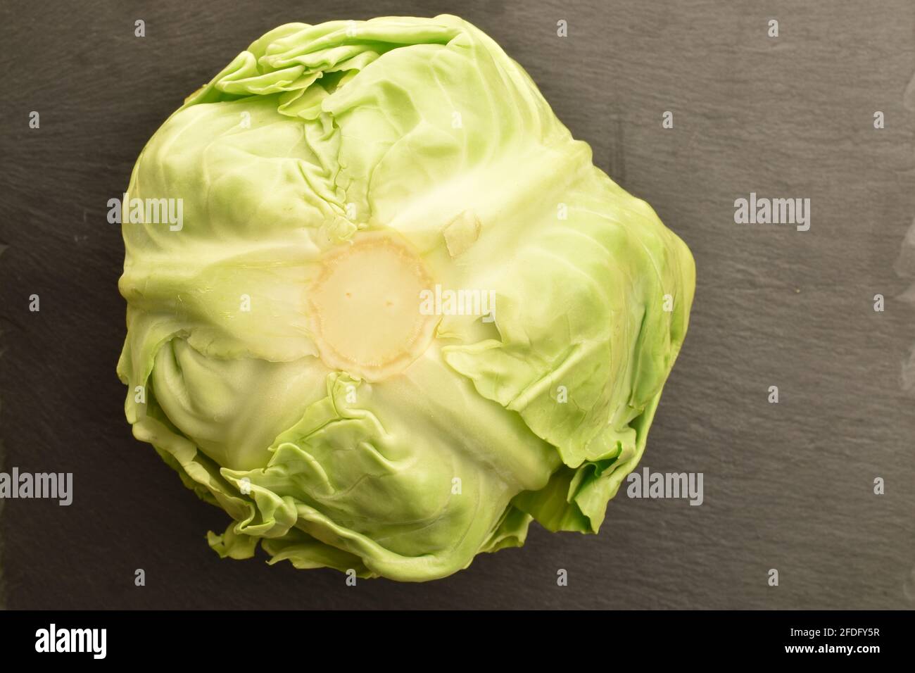 One fresh juicy organic cabbage on a serving plate of slate Stock Photo ...